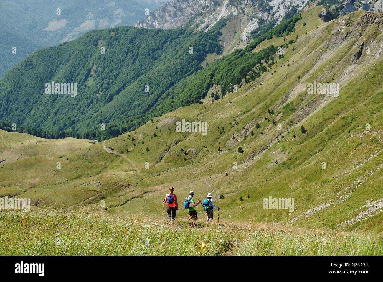 three hikers are heading to the bottom of a valley between Montenegro ...