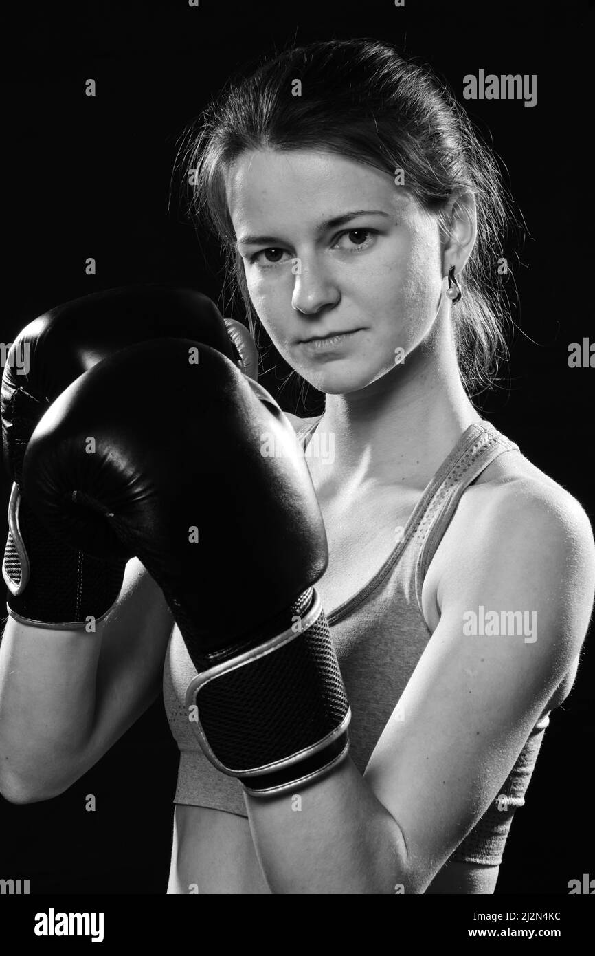 Pretty Muay Thai female boxer in attack pose. Fitness young woman ...