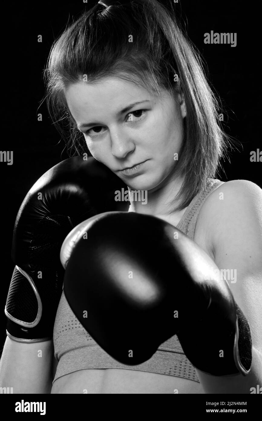 Pretty Muay Thai female boxer in attack pose. Fitness young woman ...