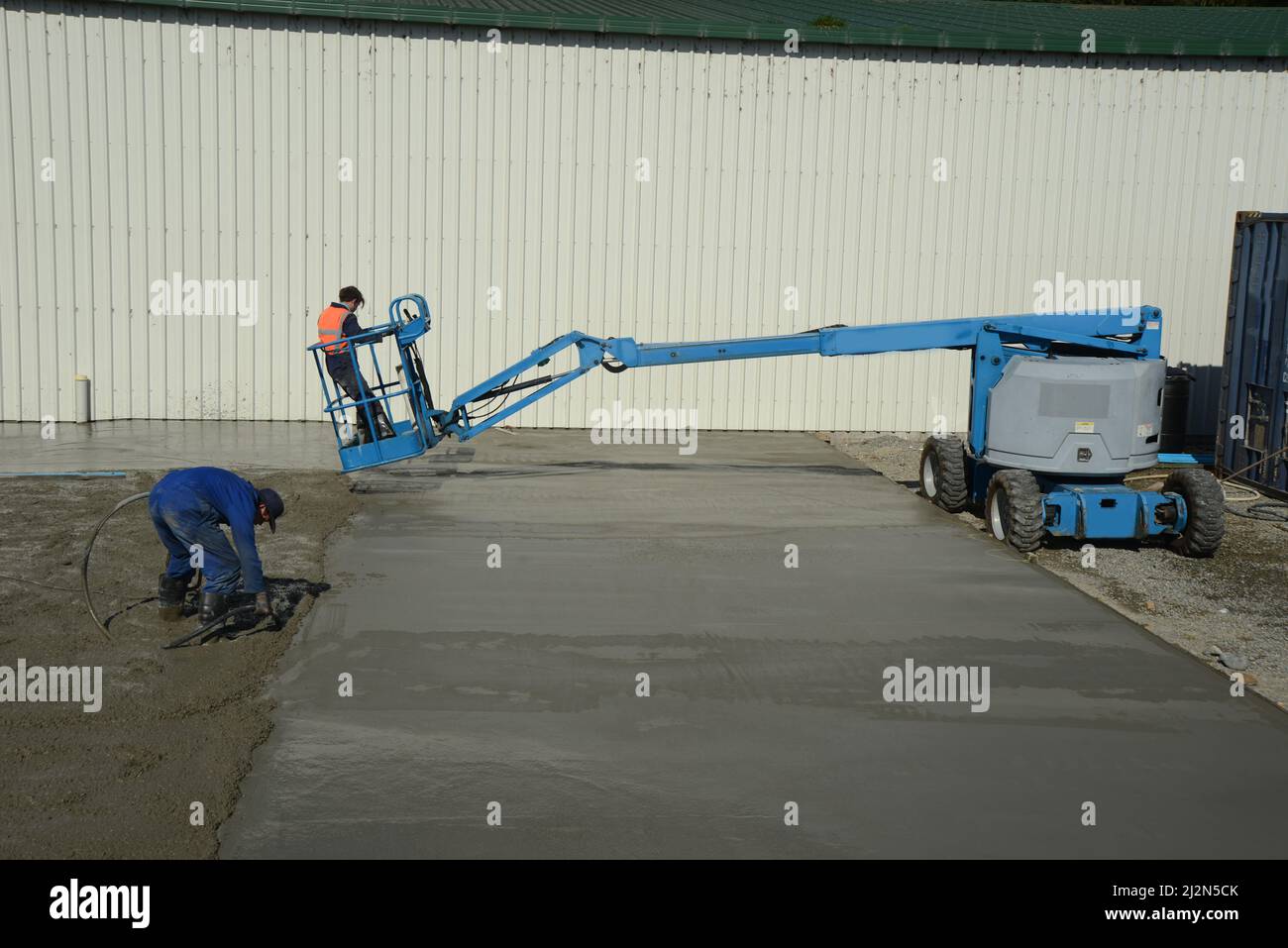 A builder uses a cherry picker to access difficult areas while floating ...