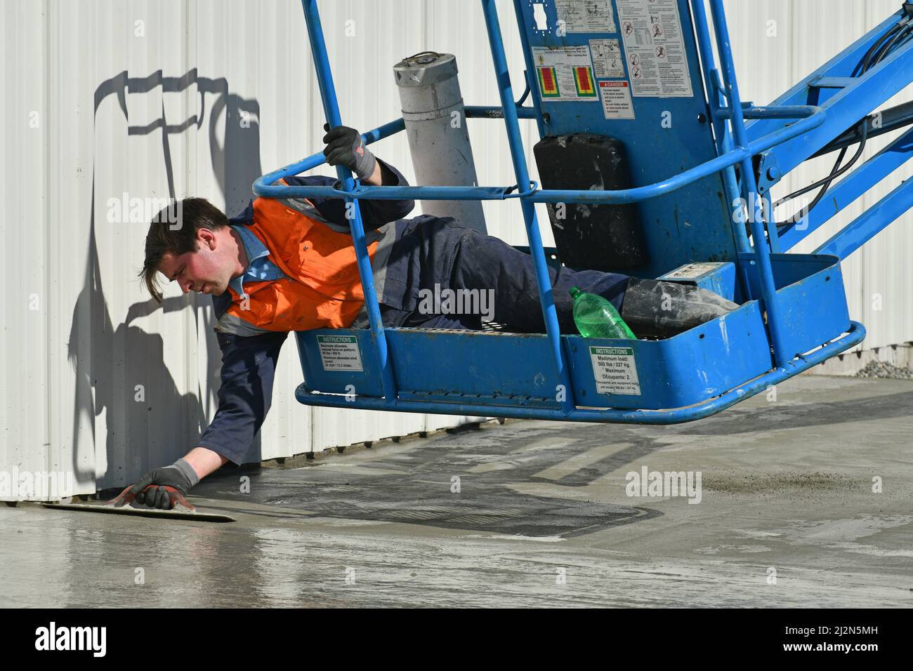 A builder uses a cherry picker to access difficult areas while floating ...