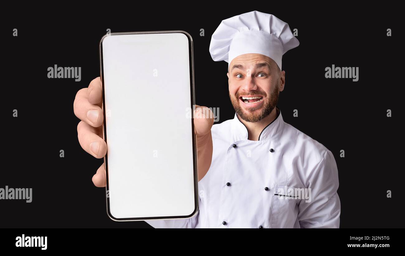 Funny Young Chef Holding Demonstrating Smartphone With Blank Screen At ...