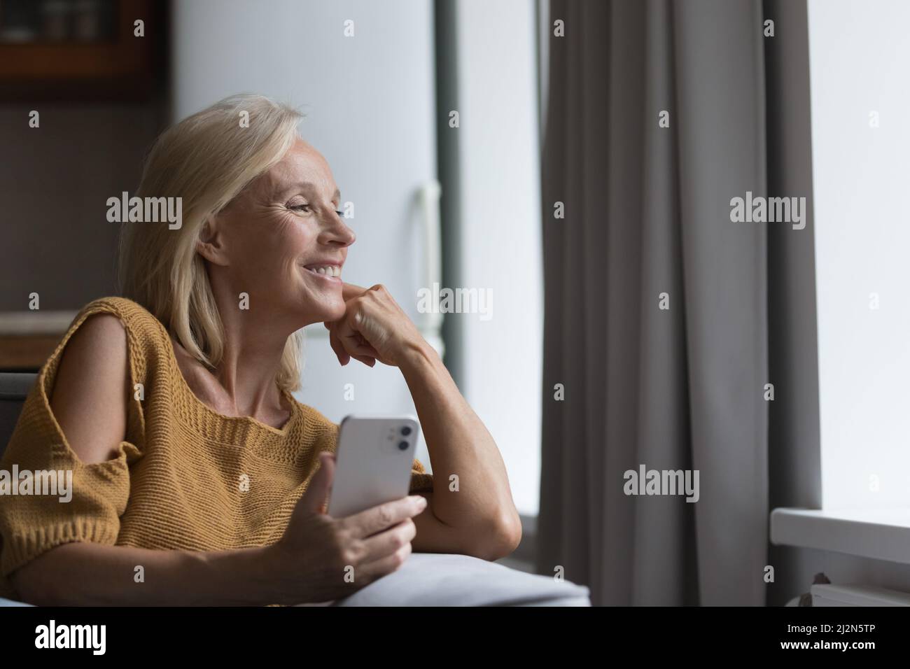 Happy senior 50s lady holding mobile phone Stock Photo - Alamy