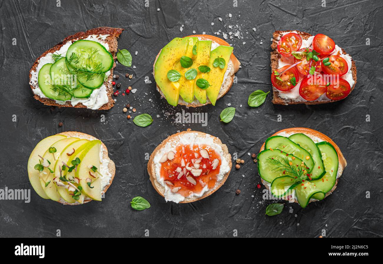 Vegetable and fruit crostini on a black background. Bruschetta with ...