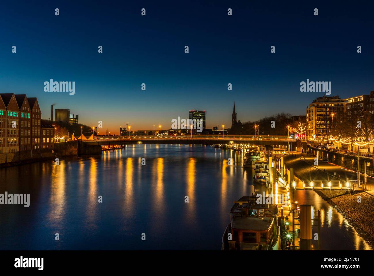Night view of Bremen with the buildings, bridges and ships reflecting ...