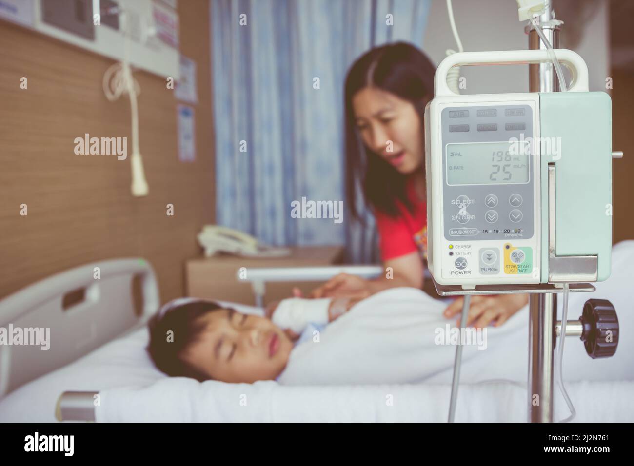 Illness asian child lying on sickbed with infusion pump intravenous IV ...