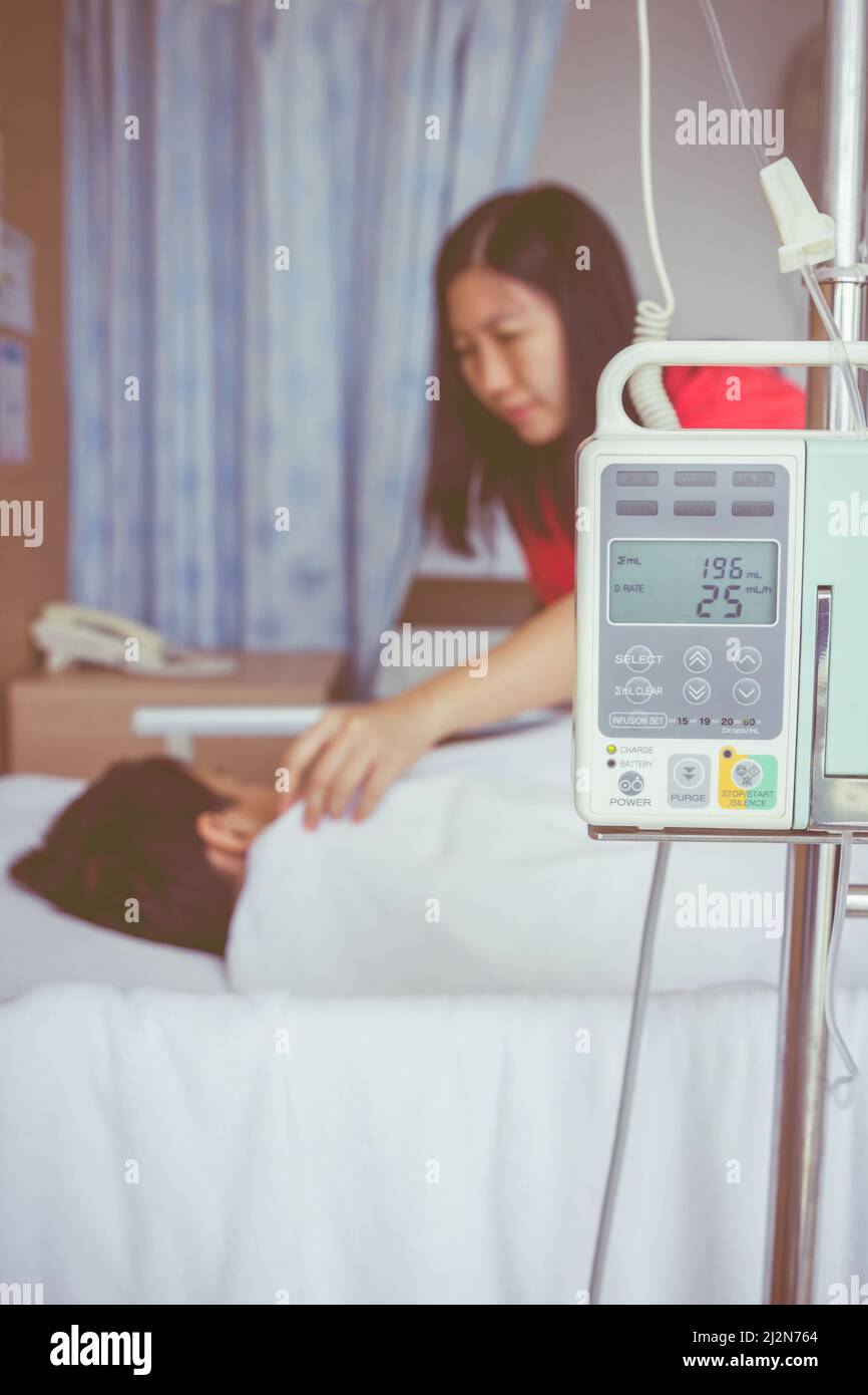 Illness asian child lying on sickbed with infusion pump intravenous IV ...
