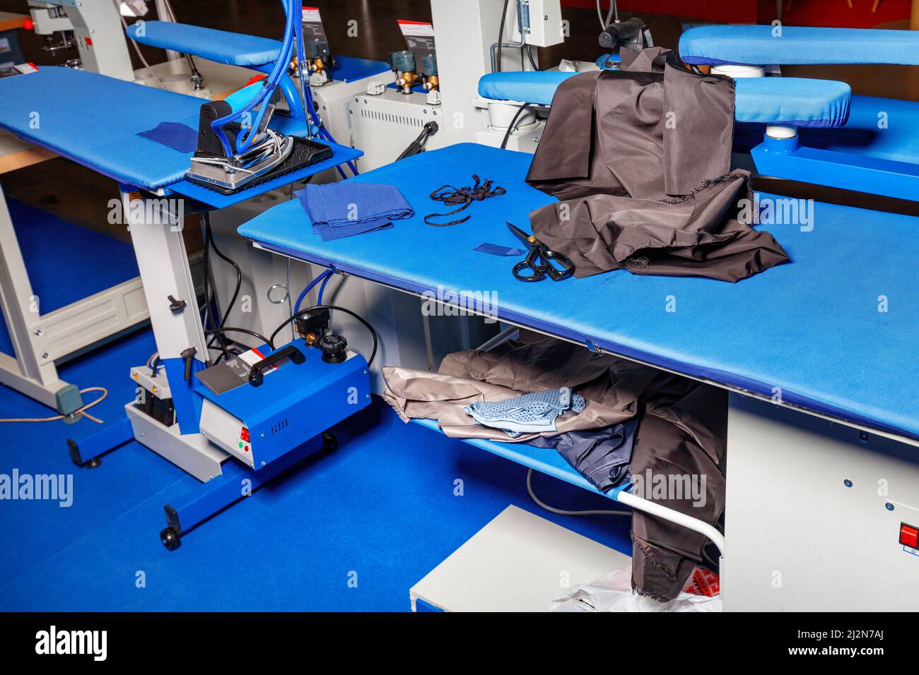 Workplaces of a professional clothes cutter with a steam iron and ...
