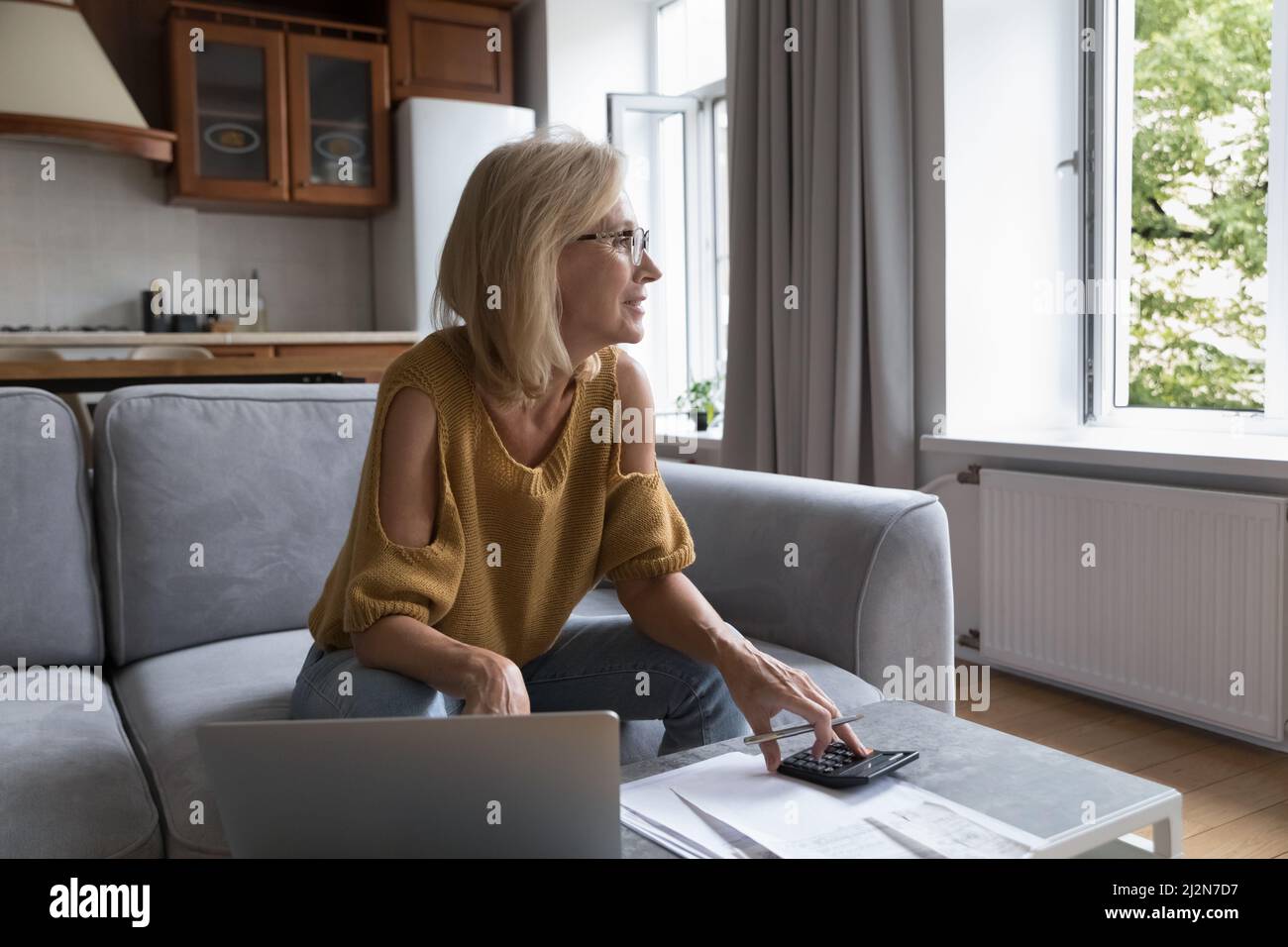 Happy dreamy homeowner woman thinking over monthly paperwork Stock ...