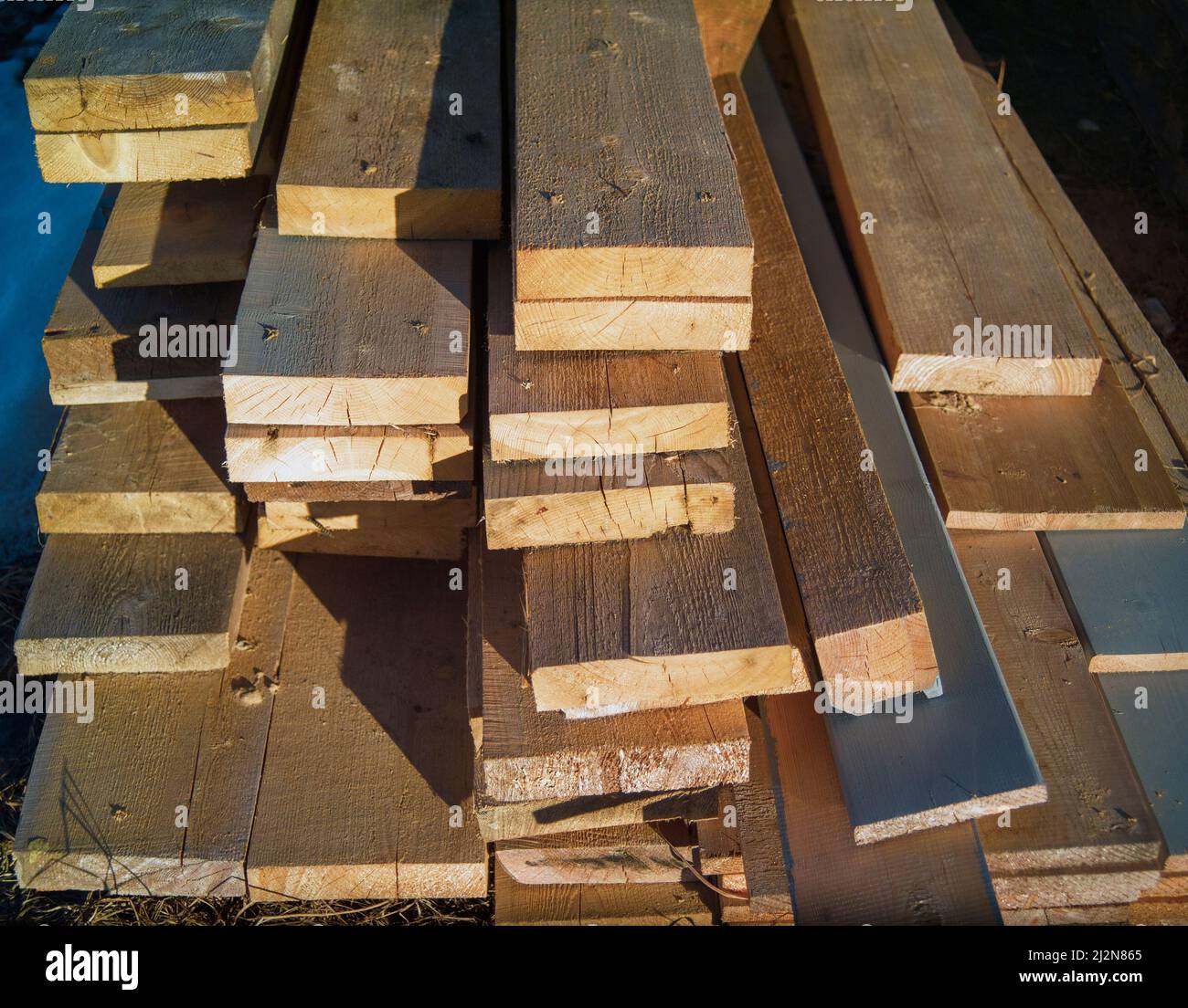 outdoor stack of cut wooden boards, sunny daylight shot Stock Photo - Alamy