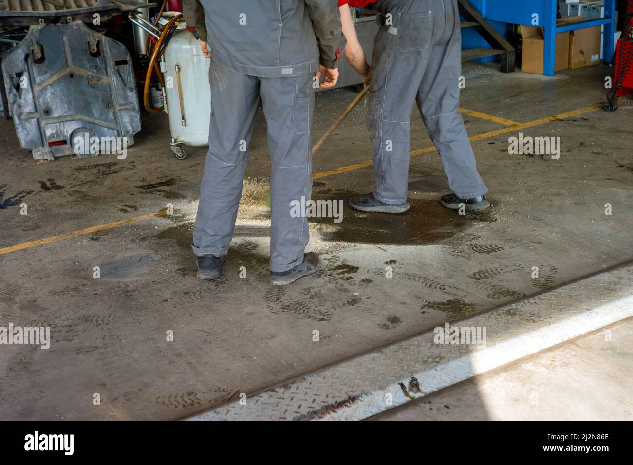 workers removing garbage on the messy floor of garage, indoor shot ...