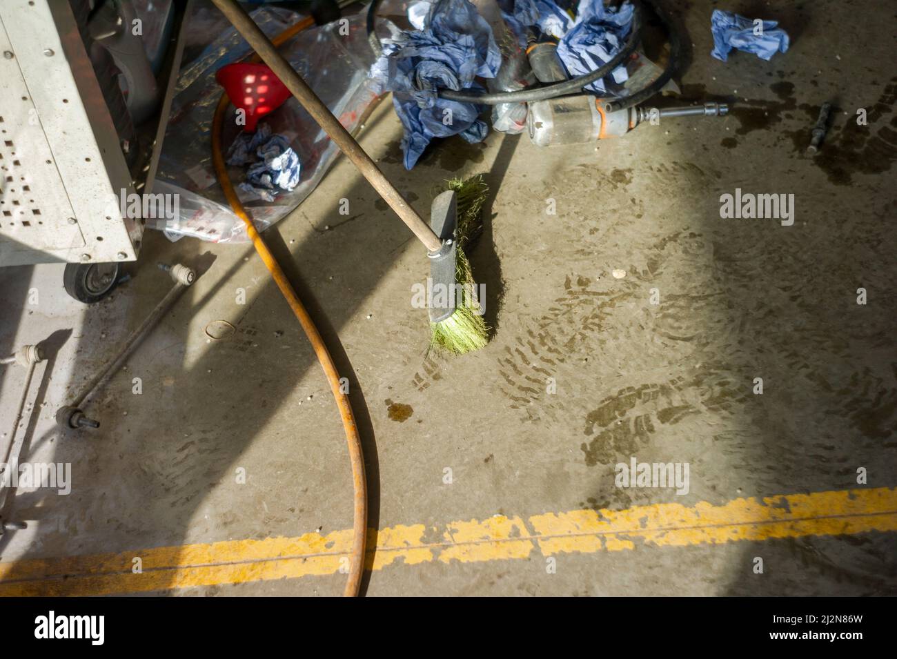 a brush and pile of garbage on a garage floor, indoor shot Stock Photo ...