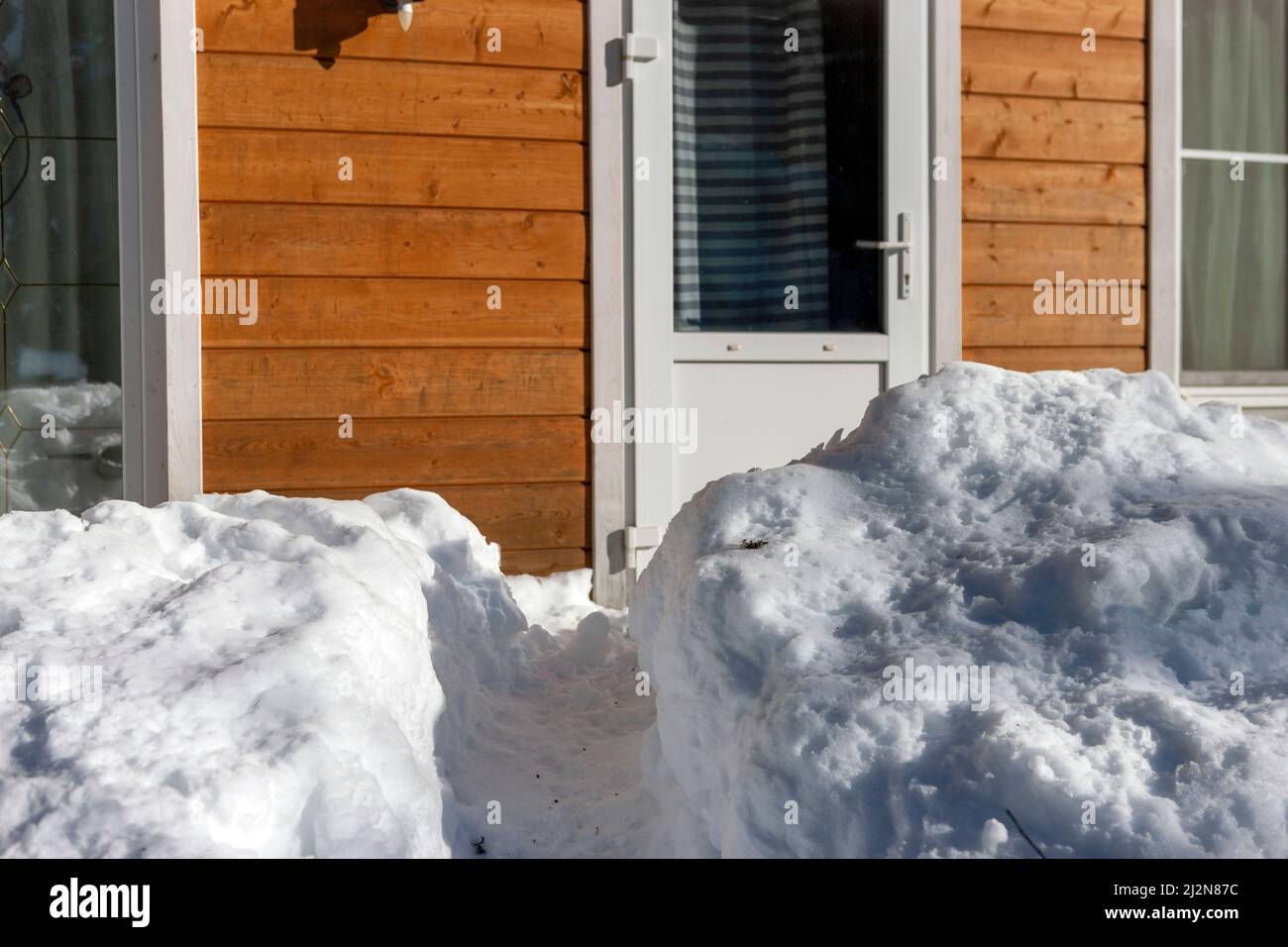 a passage dug in the snowdrift to a house entrance door, winter scene ...