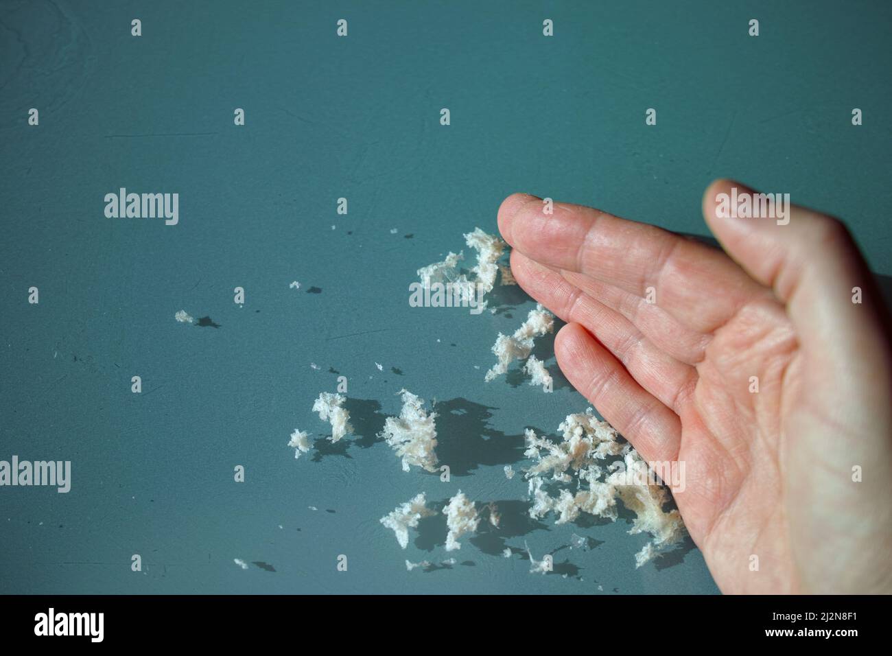 a hand wipes crumbs off the table surface, indoor close up Stock Photo ...