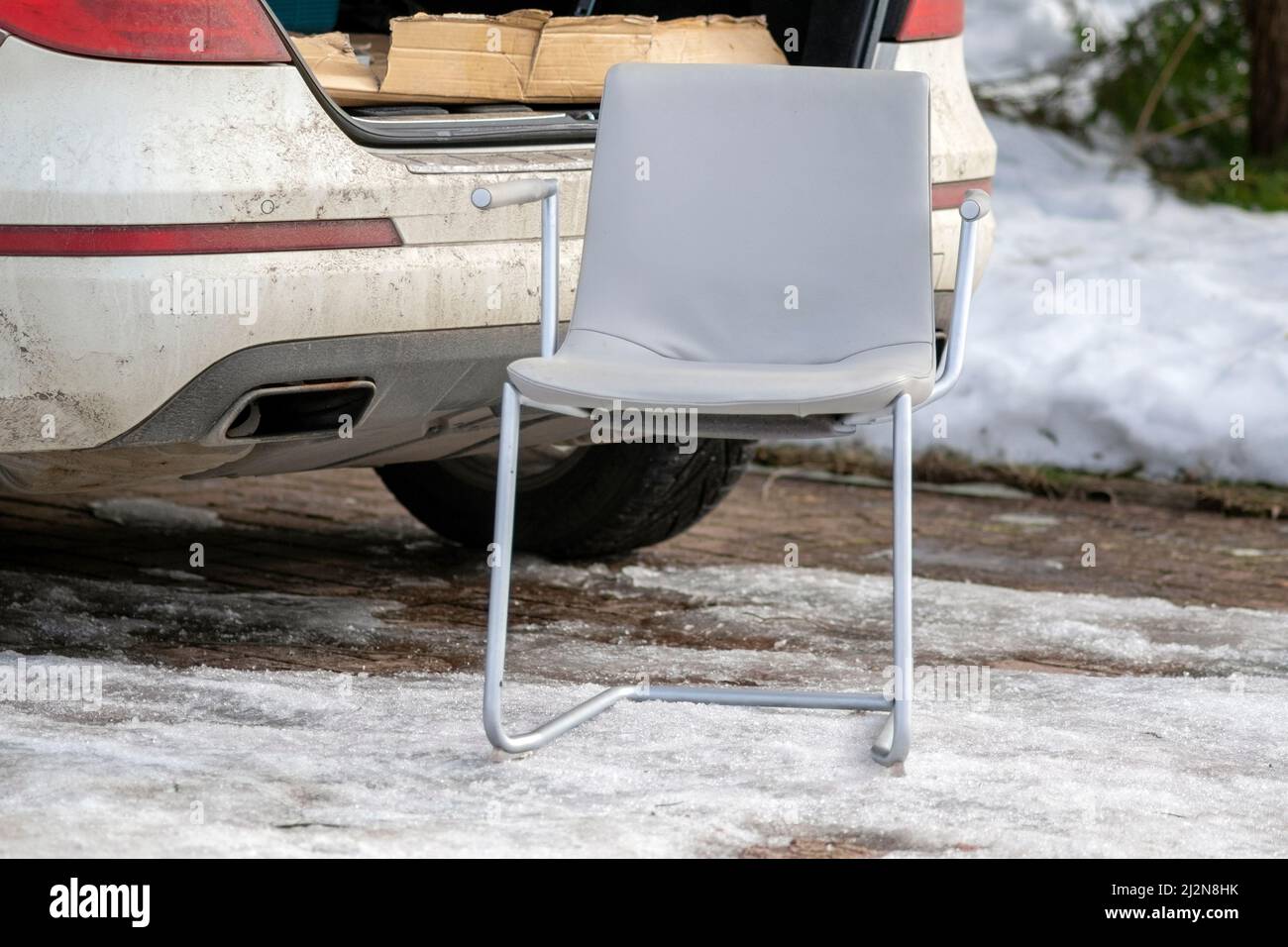 a chair with leather seat next to minivan with open rear door Stock ...
