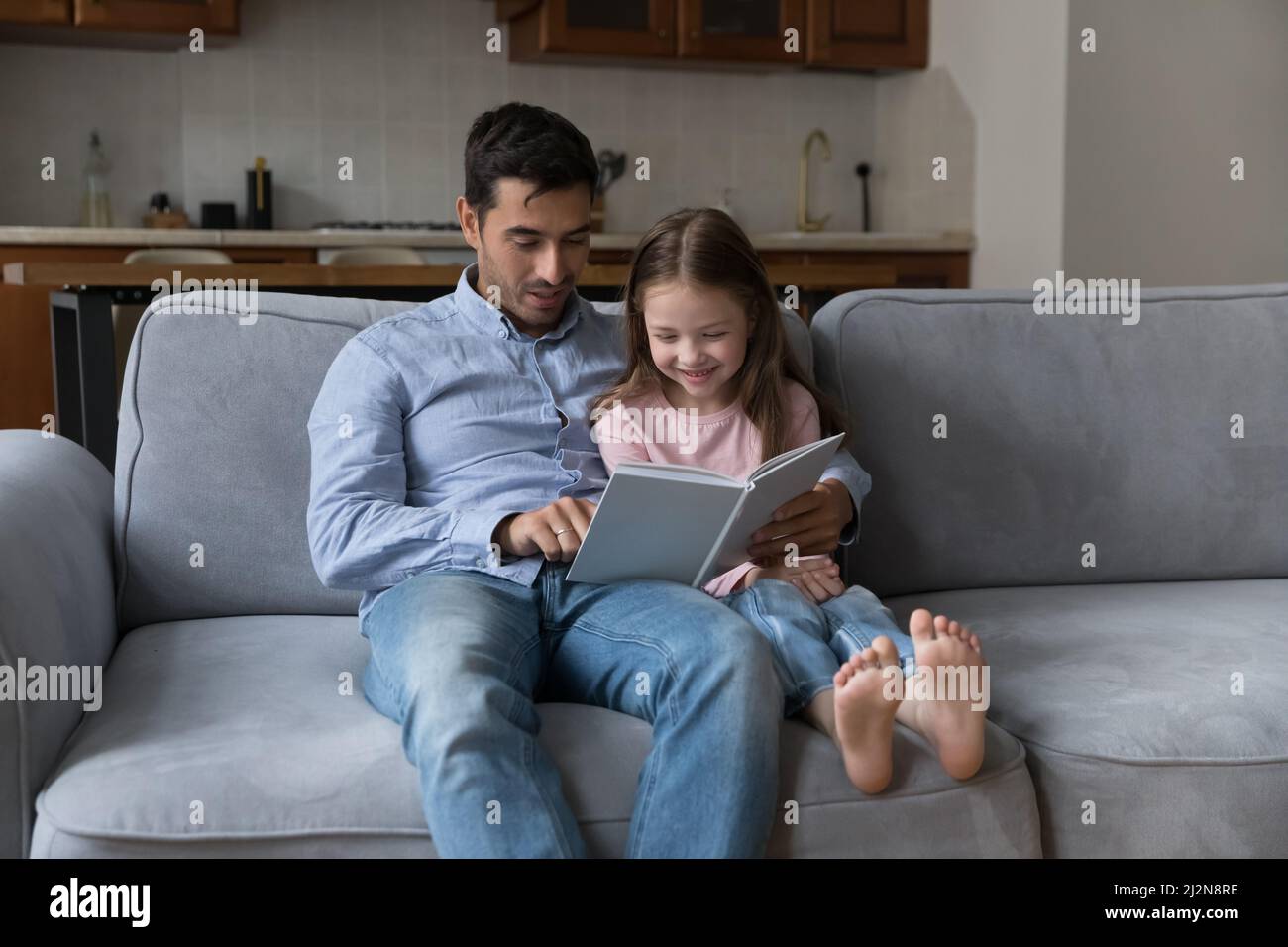 Loving caring dad and cute preschool daughter girl reading book Stock ...