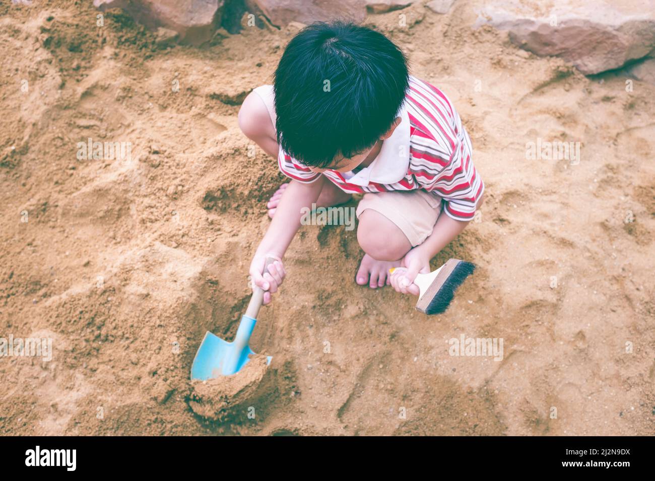 Top view. Happy child playing with sand and smiling. Adorable asian boy ...