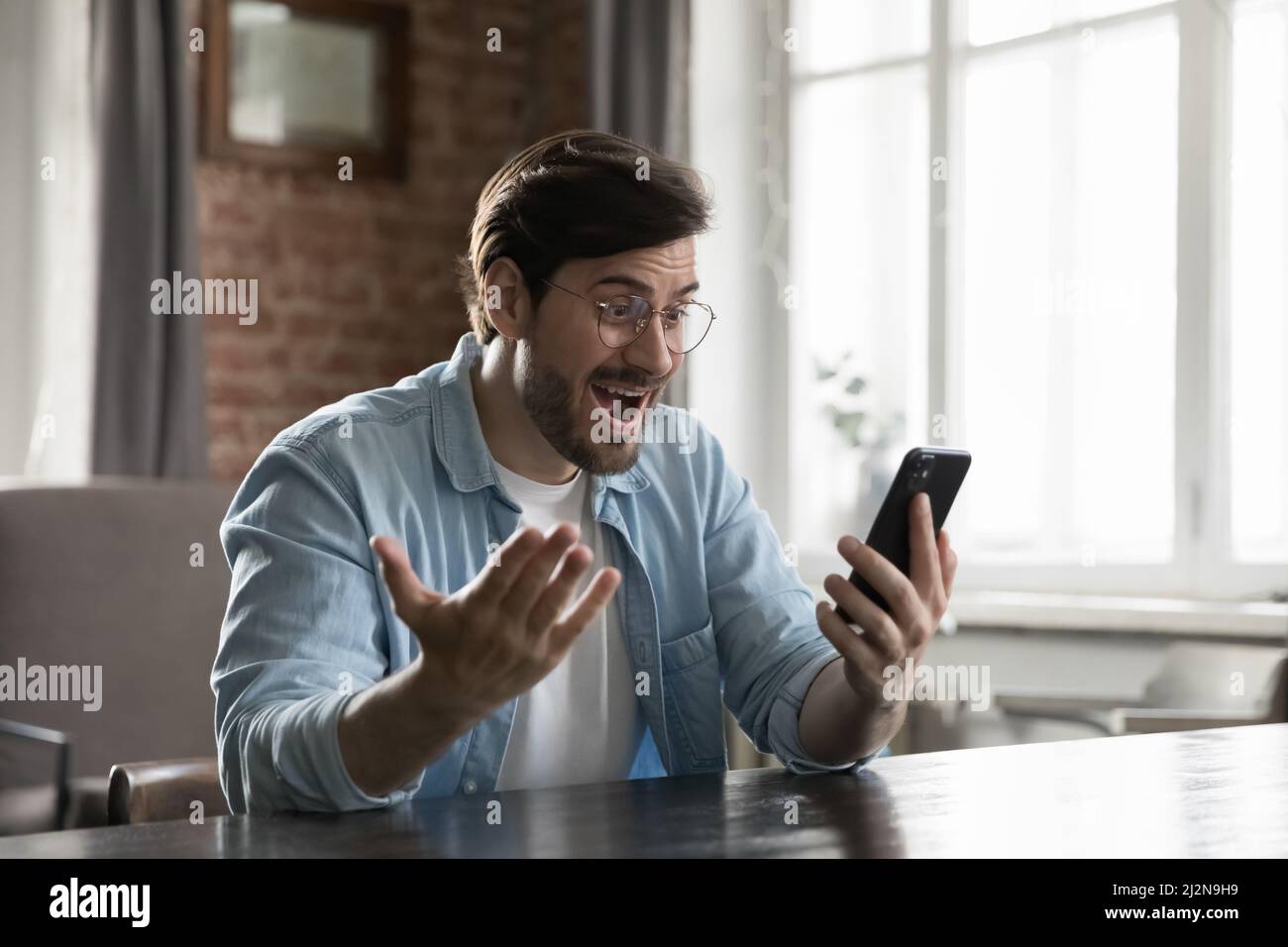 Excited smartphone user man staring at screen in surprise Stock Photo ...