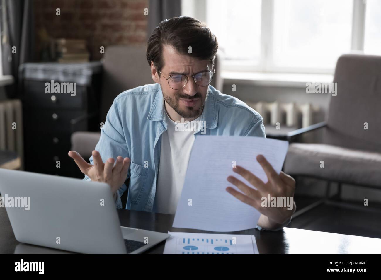 Annoyed frustrated entrepreneur looking at paper report with bad news ...