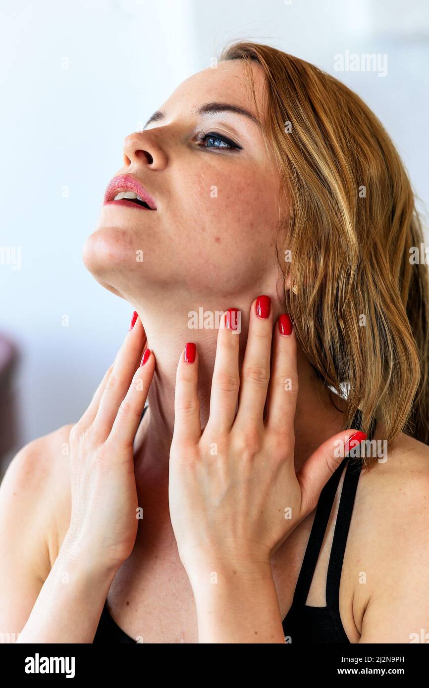 The girl holds her neck with her hands Stock Photo - Alamy