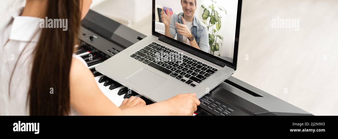 Little girl watching online lesson tutorial how to learn a synthesizer ...