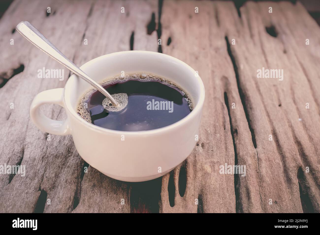 A cup of coffee on old wooden background. Vintage picture style ...