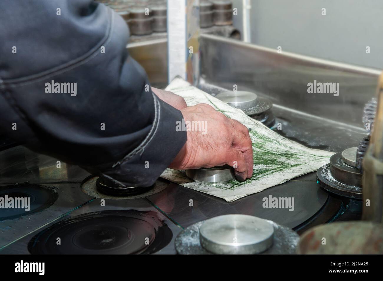 worker uses his hands to make the final polishing of stainless steel ...