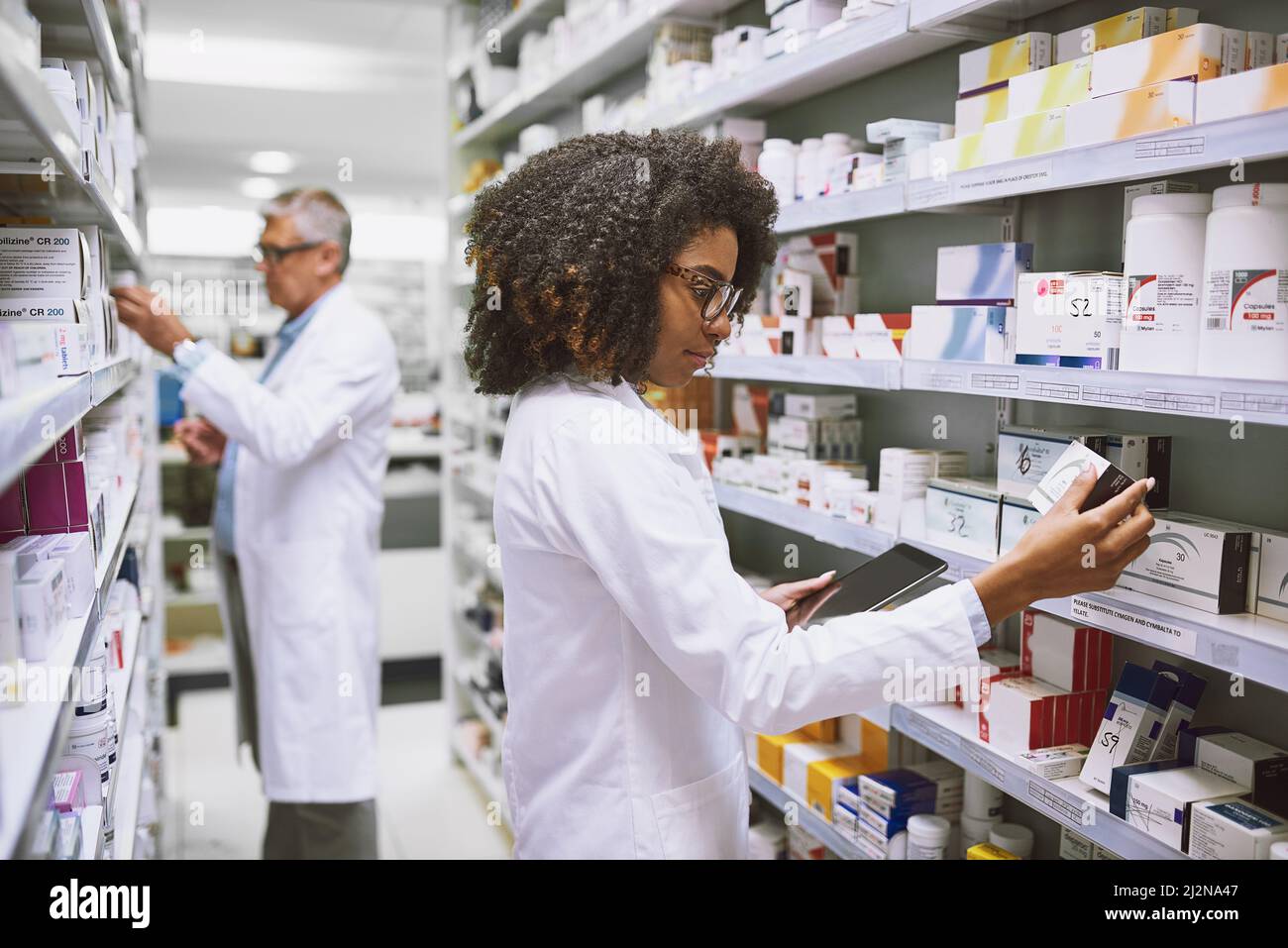 More hands equals less work. Shot of two focused pharmacist walking ...