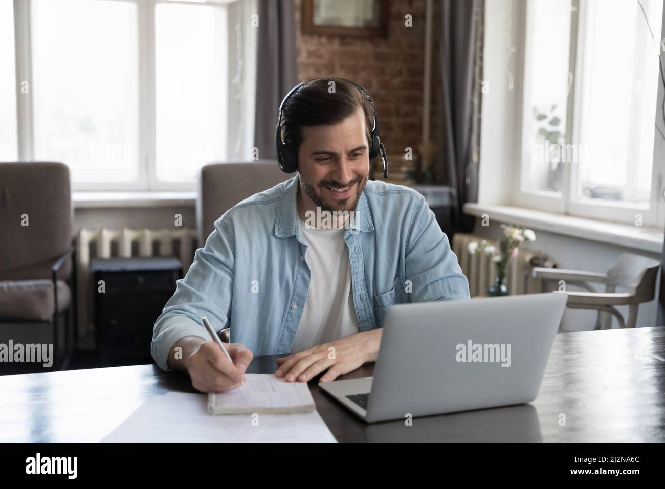 Happy student in earphones with mic attending virtual class Stock Photo ...