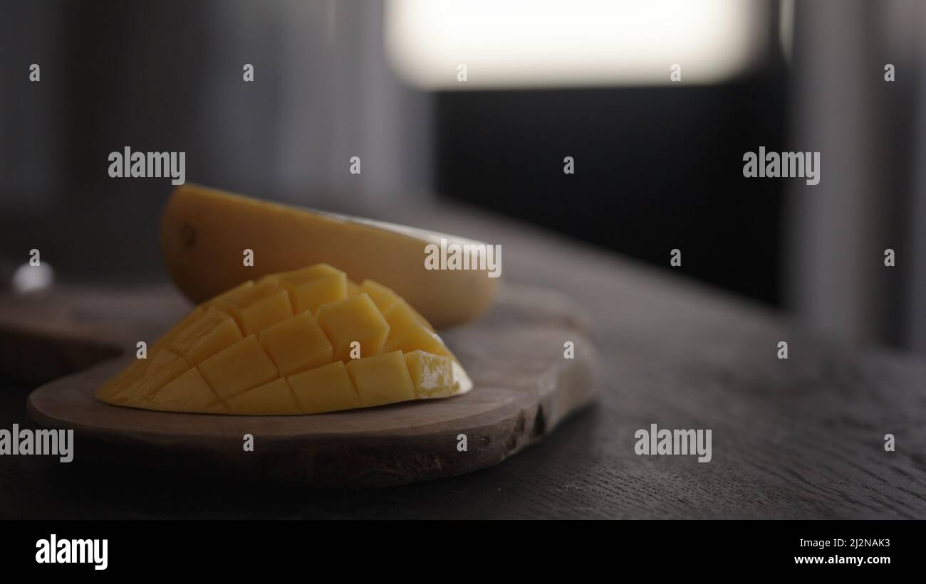 cut fresh yellow mango on wood board, wide photo Stock Photo - Alamy