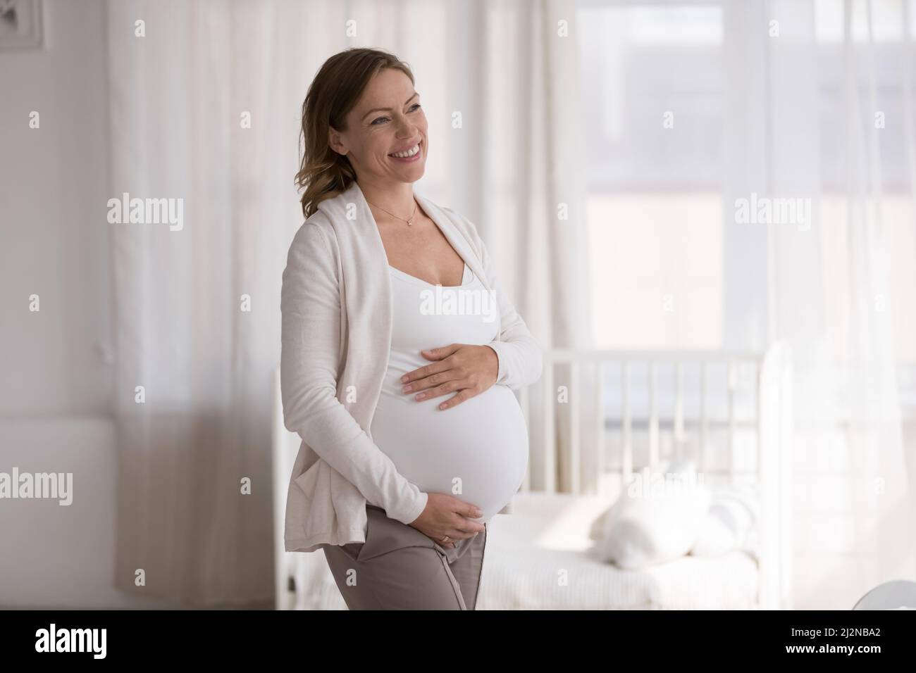 Happy cheerful expecting mom touching big baby bump Stock Photo - Alamy