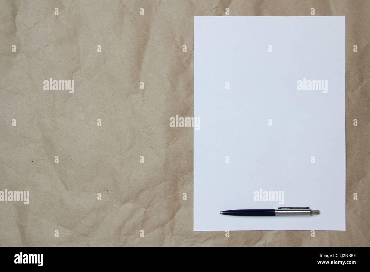 White empty sheet of A4 format with pen on a beige craft paper. Concept ...