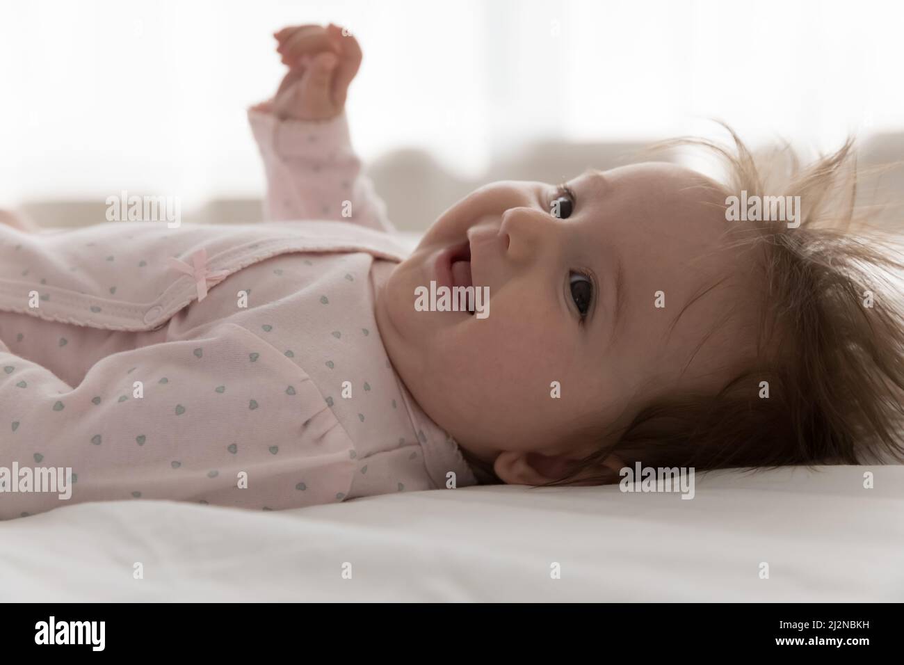 Happy adorable few month baby lying on white linen sheet Stock Photo ...