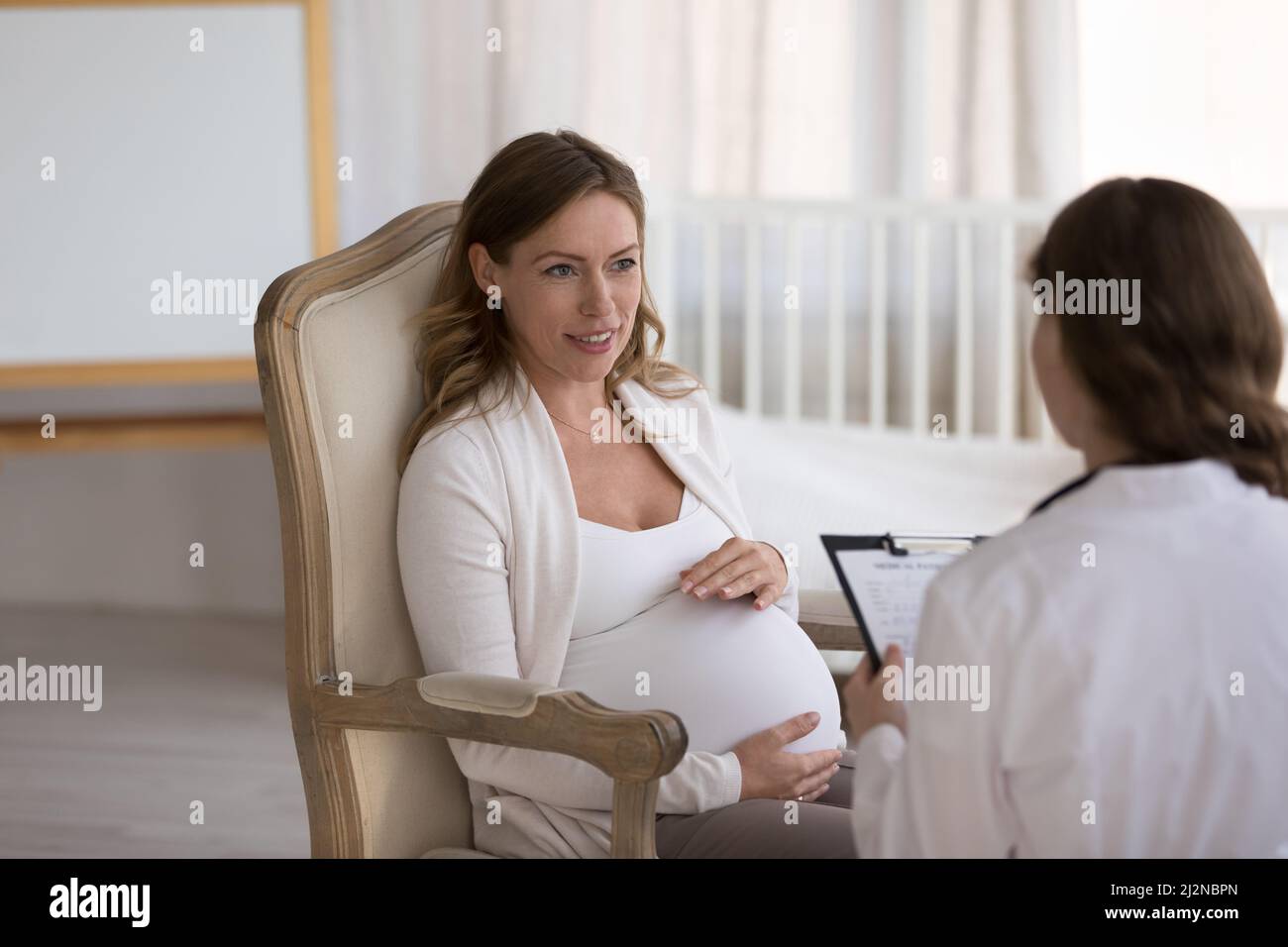 Gynecologist doctor meeting with pregnant patient, asking questions ...