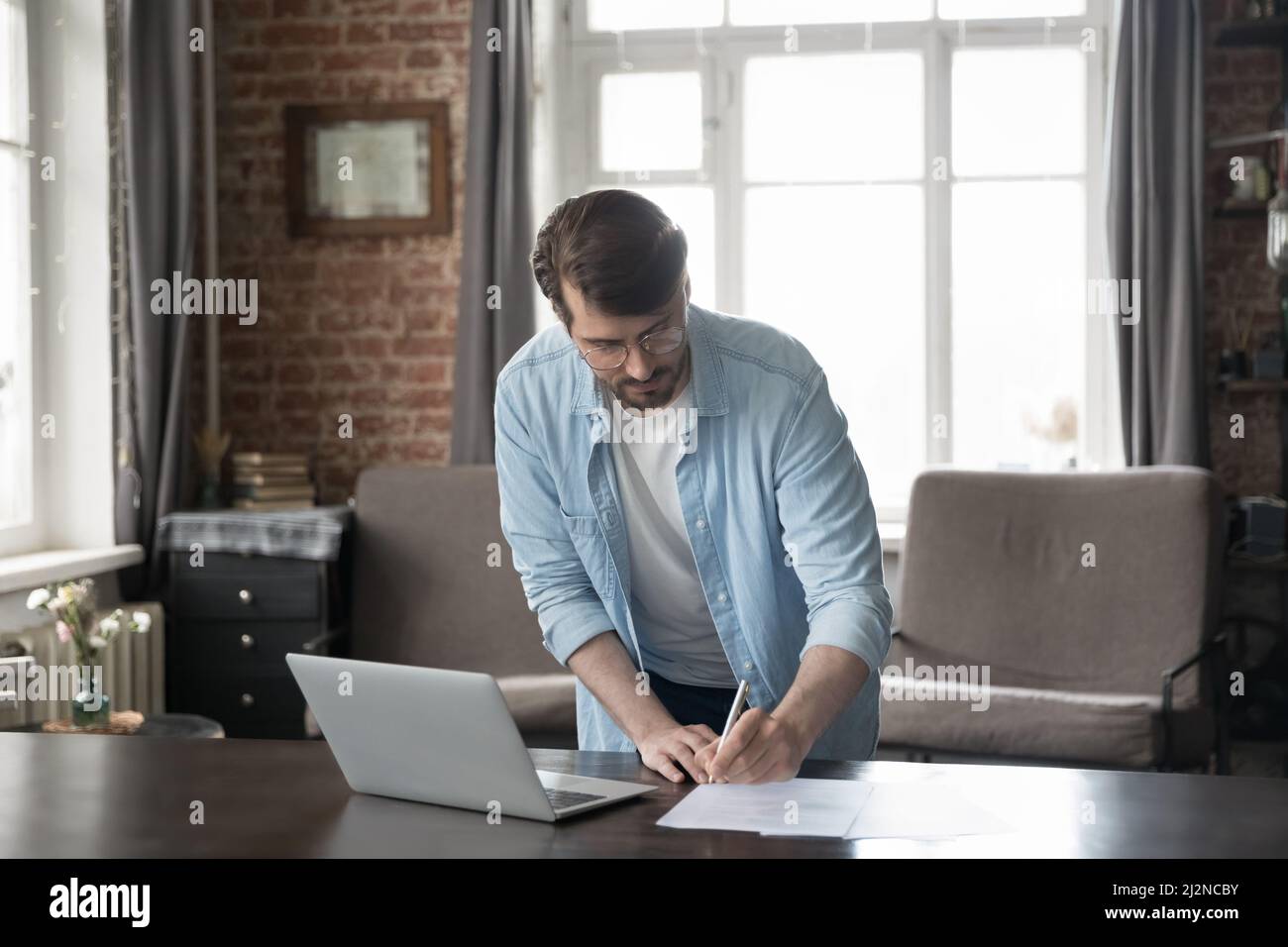 Busy focused business man signing paper contract, checking documents ...
