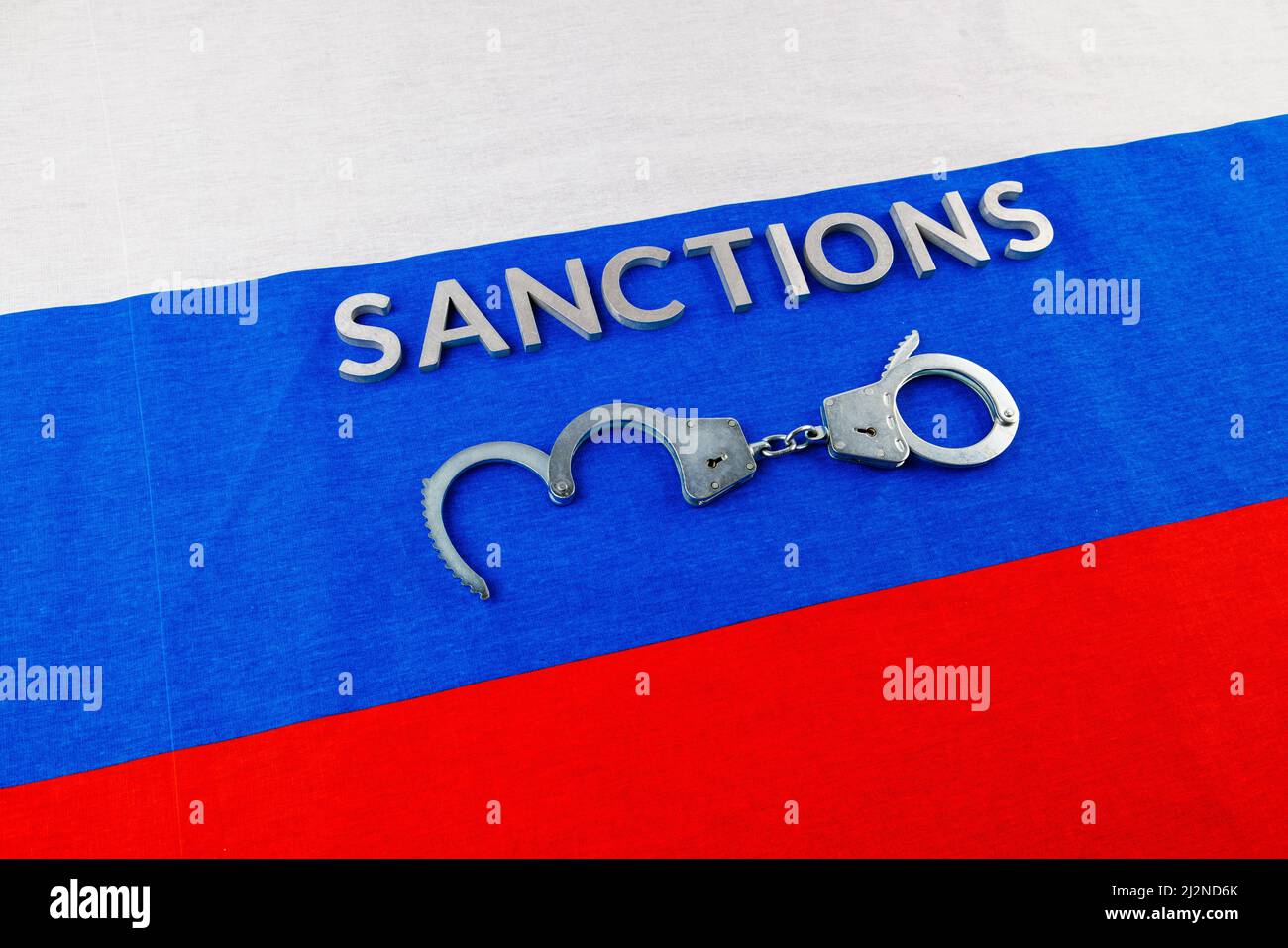 the word sanctions laid with silver metal letters on russian tricolor ...