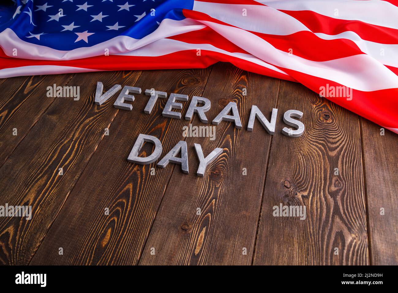 the words veterans day laid with silver metal letters on wooden board ...