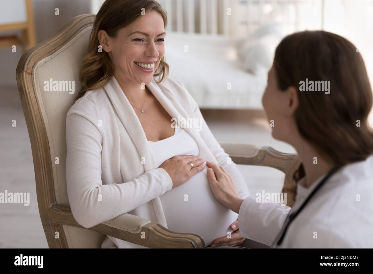 Obstetrician doctor visiting happy pregnant patient woman at home Stock ...