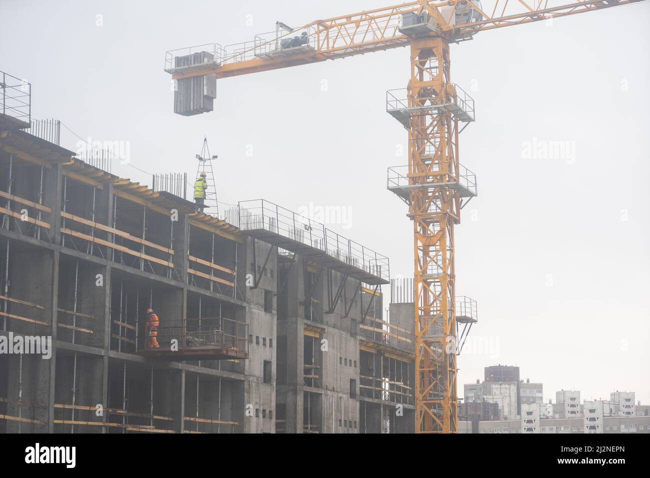 Large residential tower under construction with yellow large cranes ...