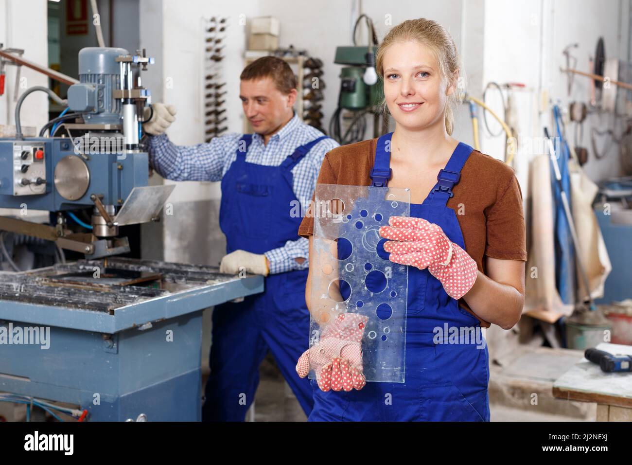 Female worker demonstrating drilled glass Stock Photo - Alamy