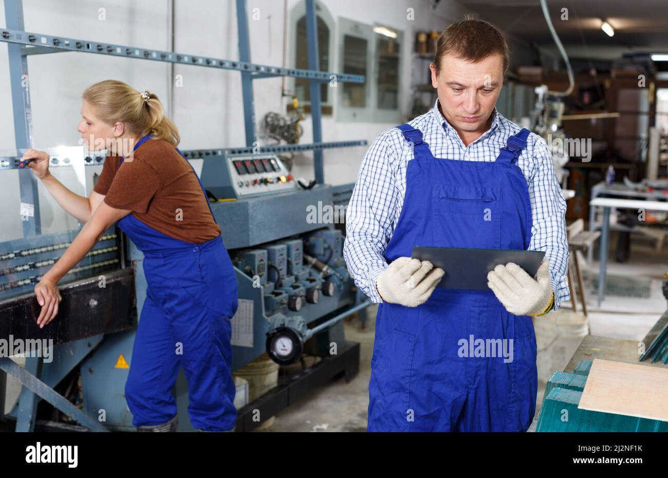 Male glazier working in glass factory Stock Photo - Alamy