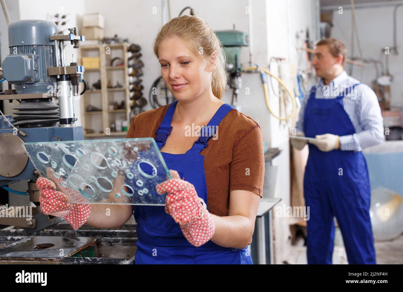 Female worker of glass factory drilling bores on machine Stock Photo ...