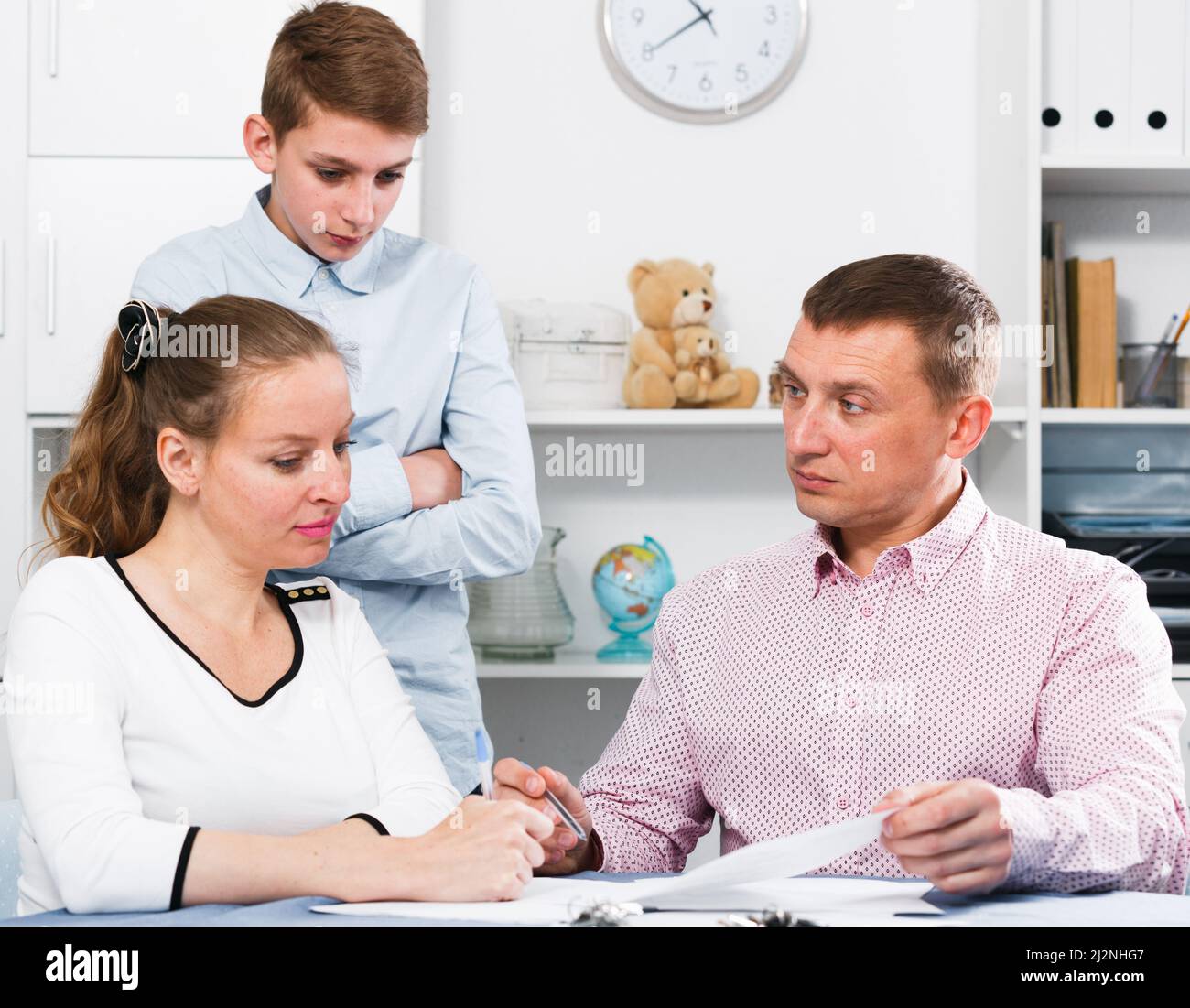 Mother and son signing documents Stock Photo - Alamy