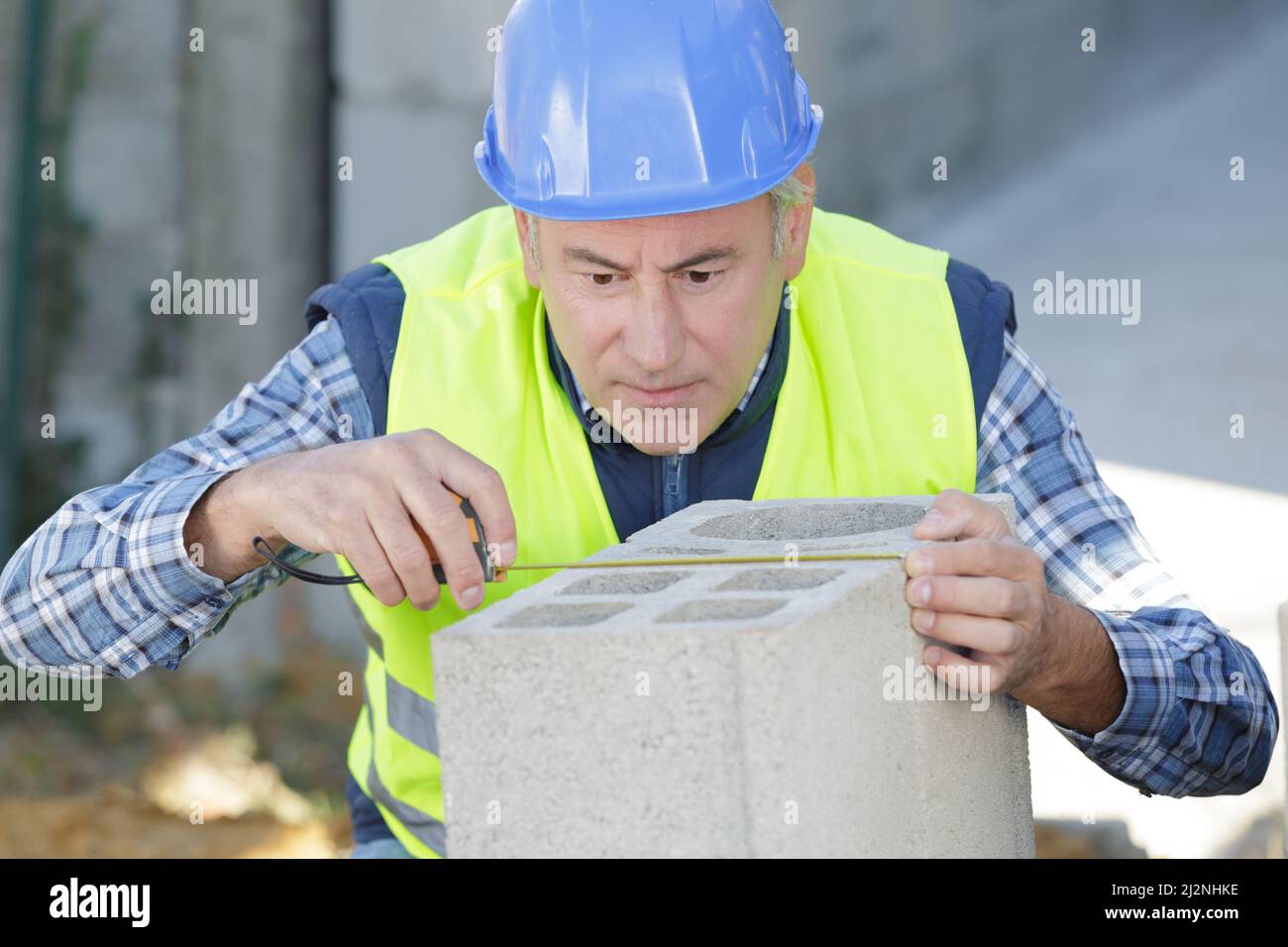 man measuring a concrete square block at a construction site Stock ...