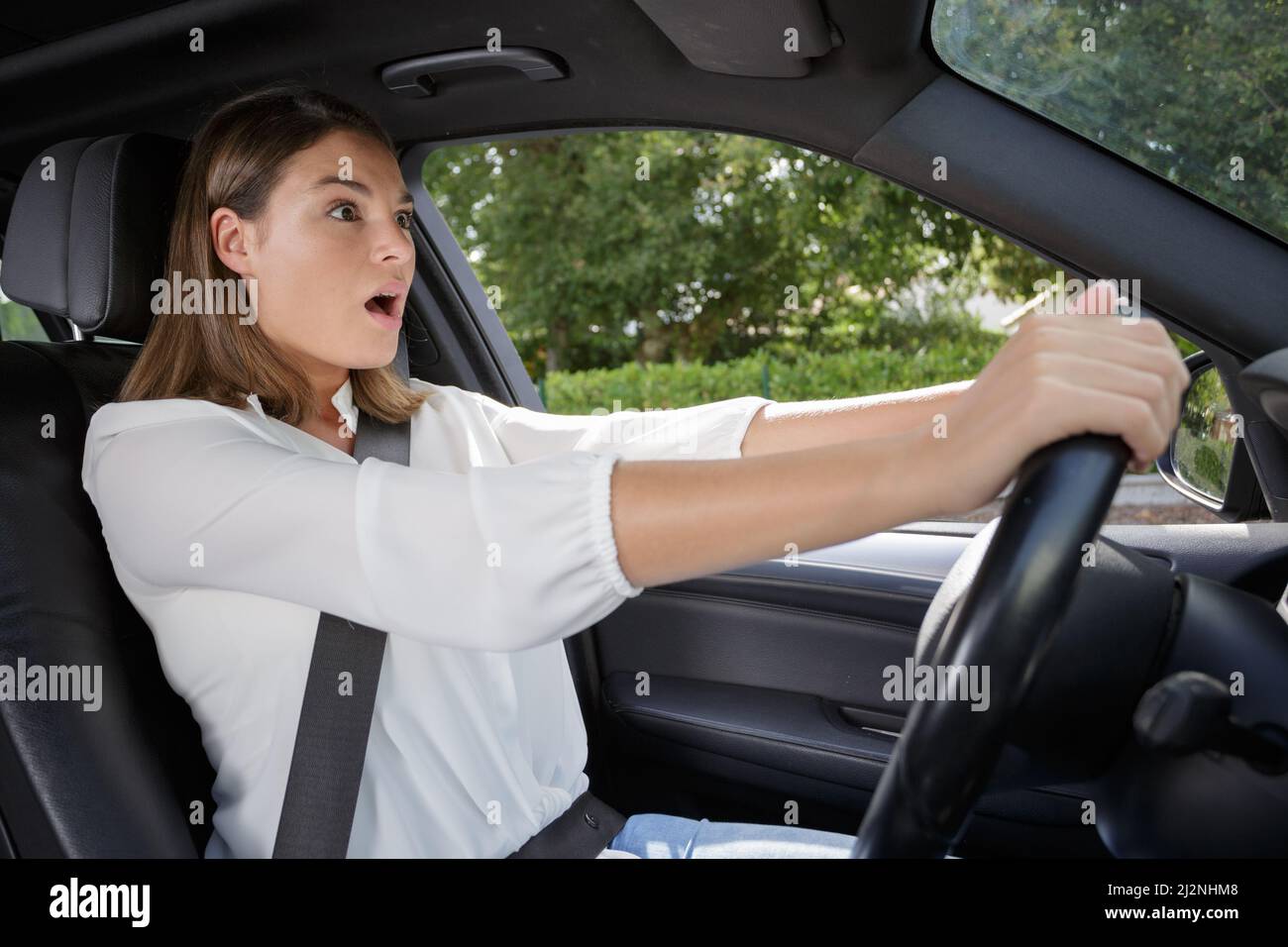 young shocked woman while driving car Stock Photo - Alamy