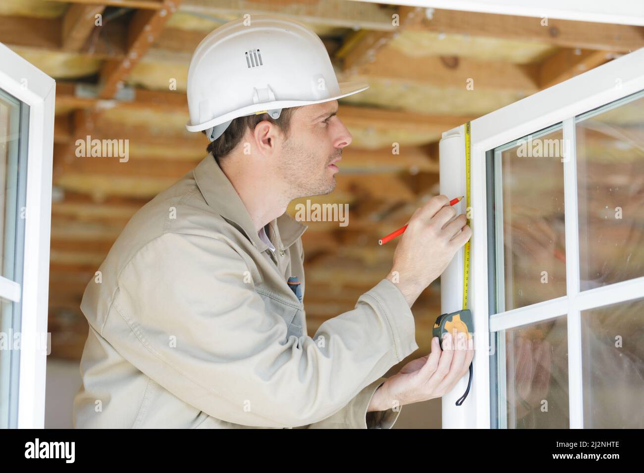 man measuring window prior to installation Stock Photo - Alamy