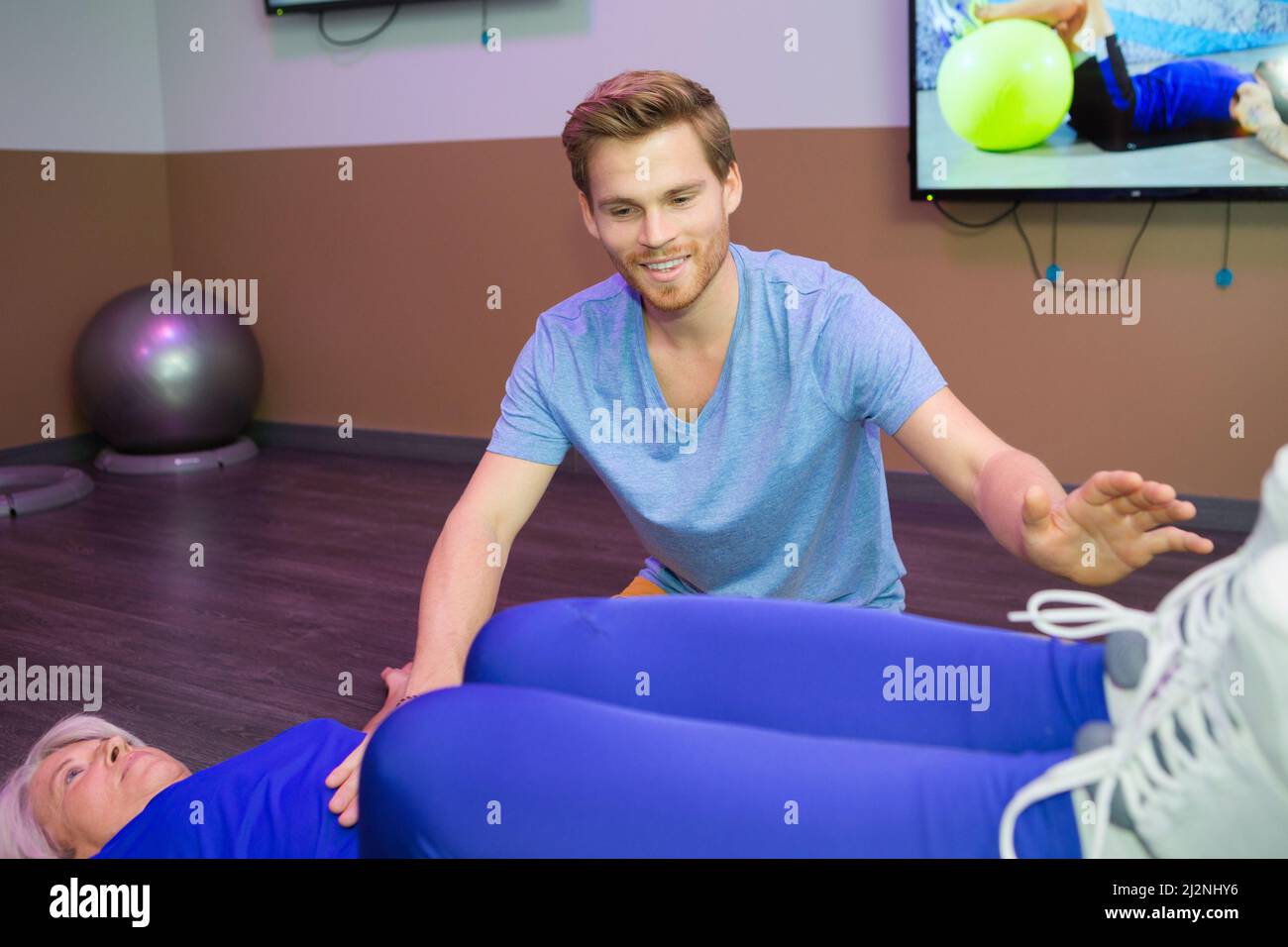 personal trainer helping senior woman exercising Stock Photo - Alamy