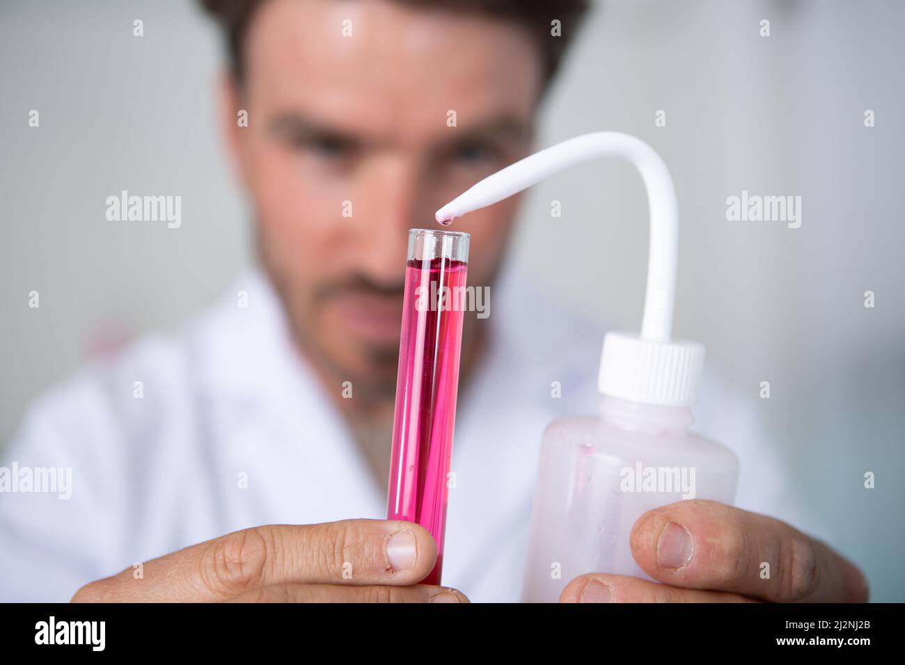 male scientist dripping reagent from pipette Stock Photo - Alamy