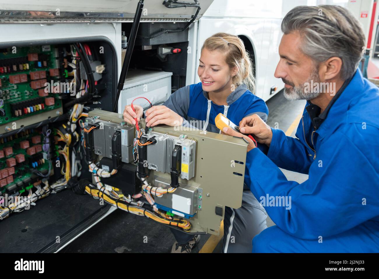 mechanics checking tourist bus before travel Stock Photo - Alamy