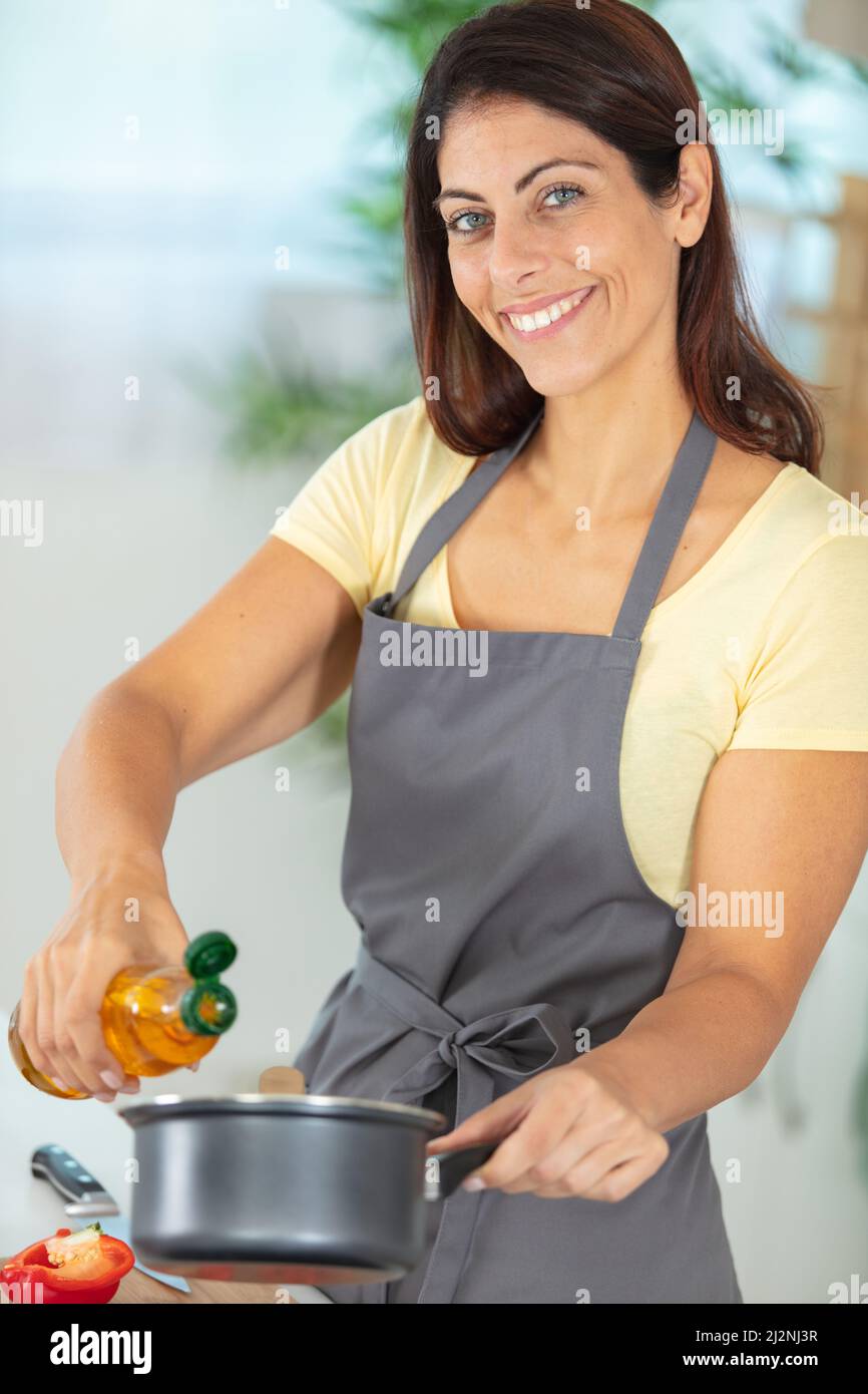 woman cooking adds oil to saucepan Stock Photo - Alamy